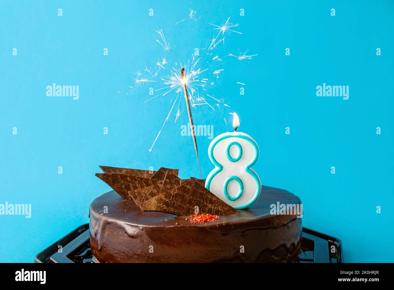 Number 8 birthday candle burning and sparkler with sparks fly on cake ...