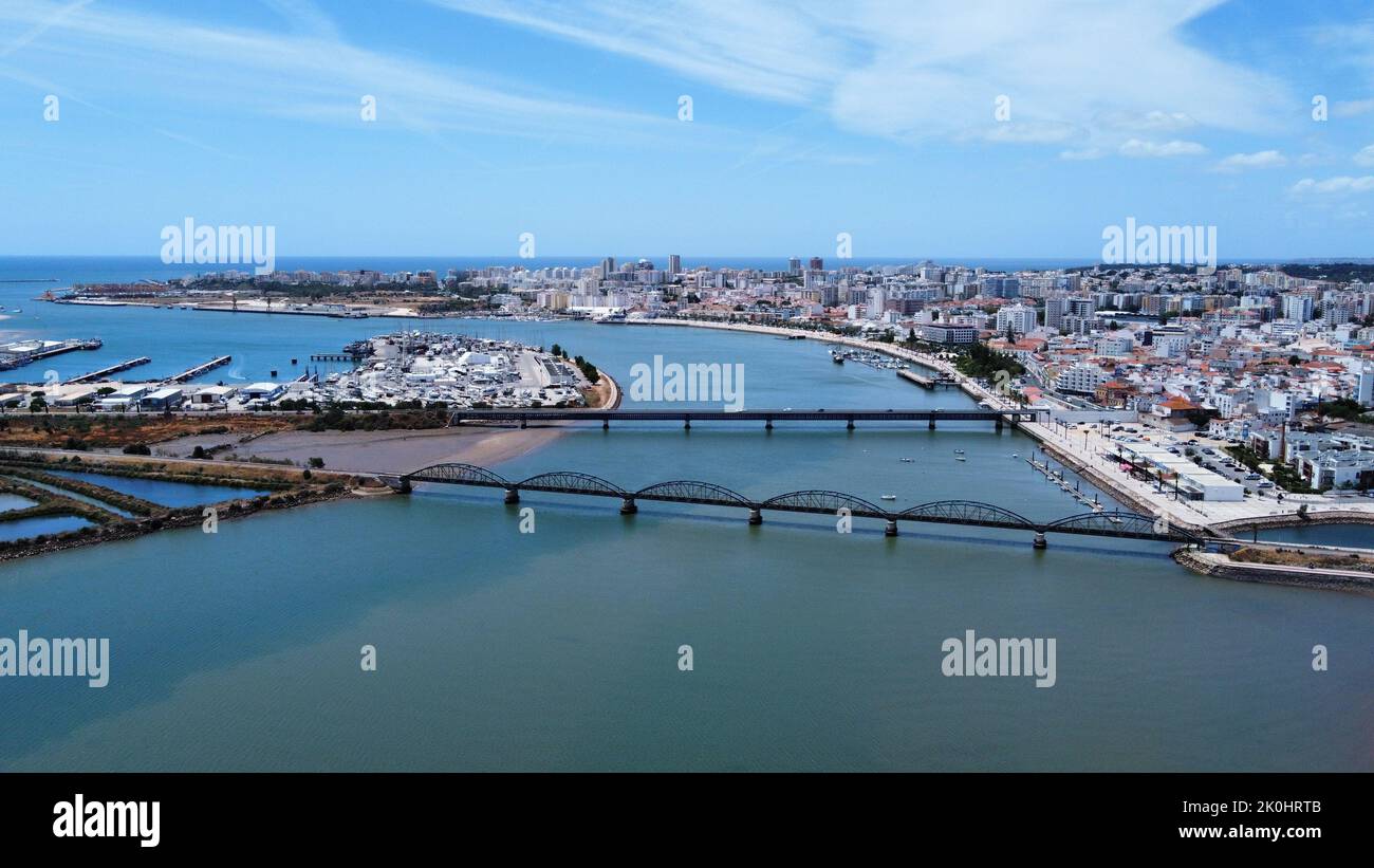 A drone view of the Arade Railway Bridge in Portugal with the town of ...