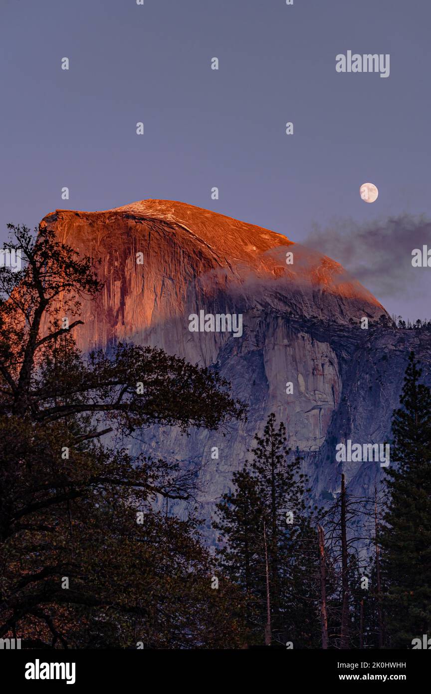 A vertical shot of a beautiful sunset over the Half Dome mountain peak ...