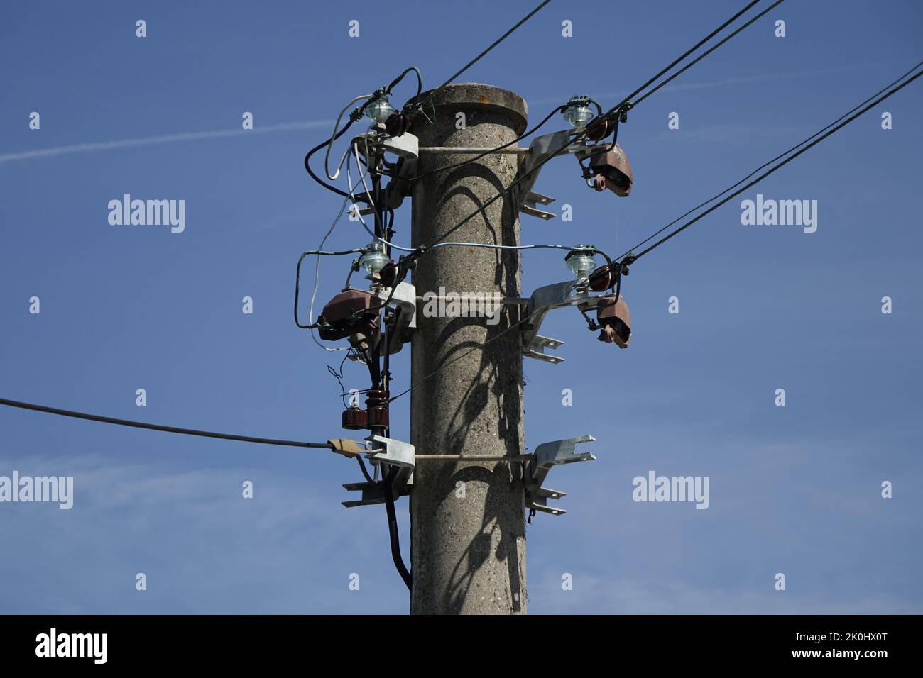 An electric post with wire and a blue sky background Stock Photo - Alamy