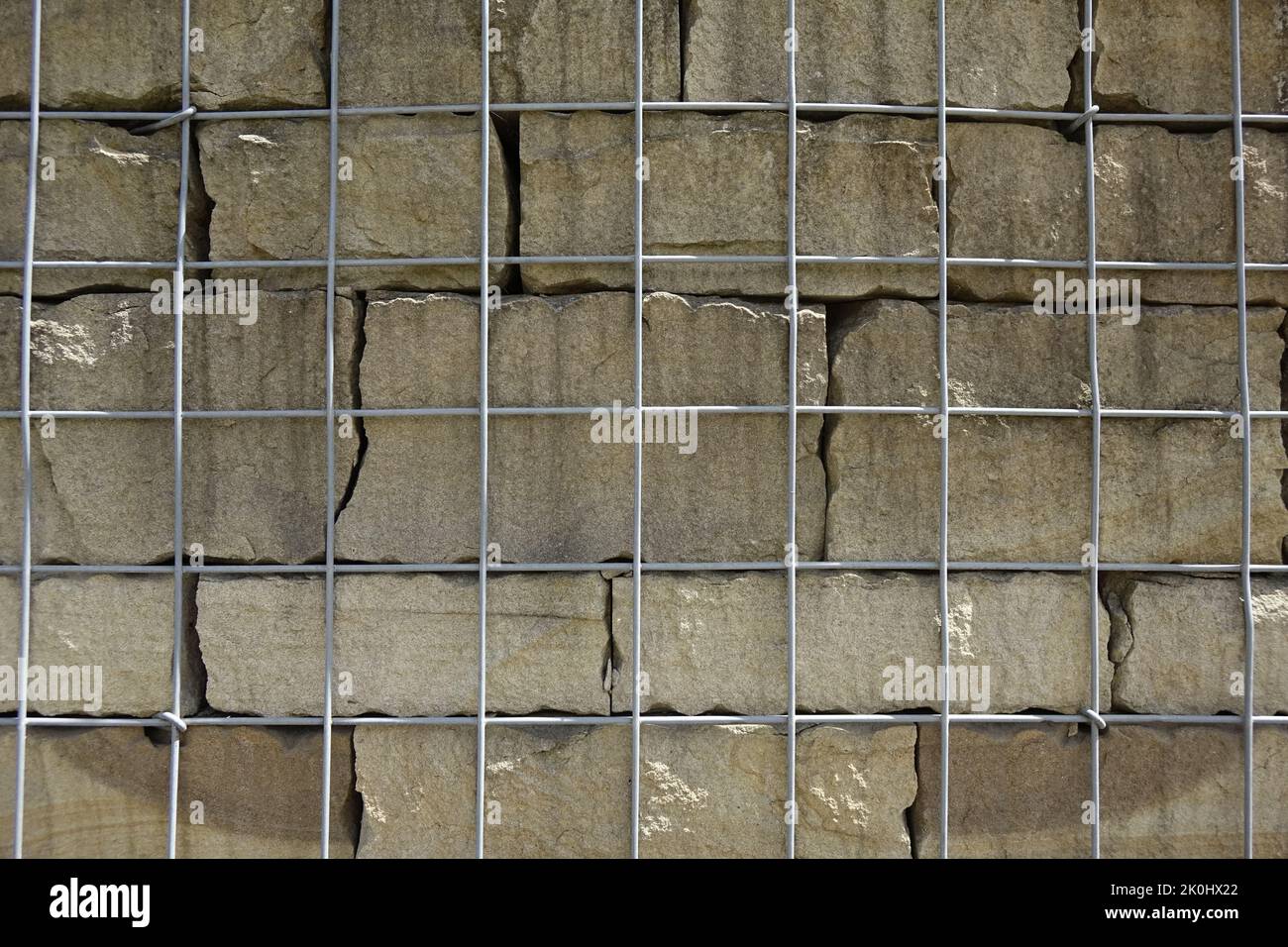 A steel wire fence with stone brick inside Stock Photo - Alamy