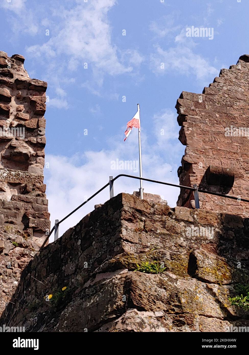 A low angle of a flag on the Nanstein Castle ruins in Landstuhl ...