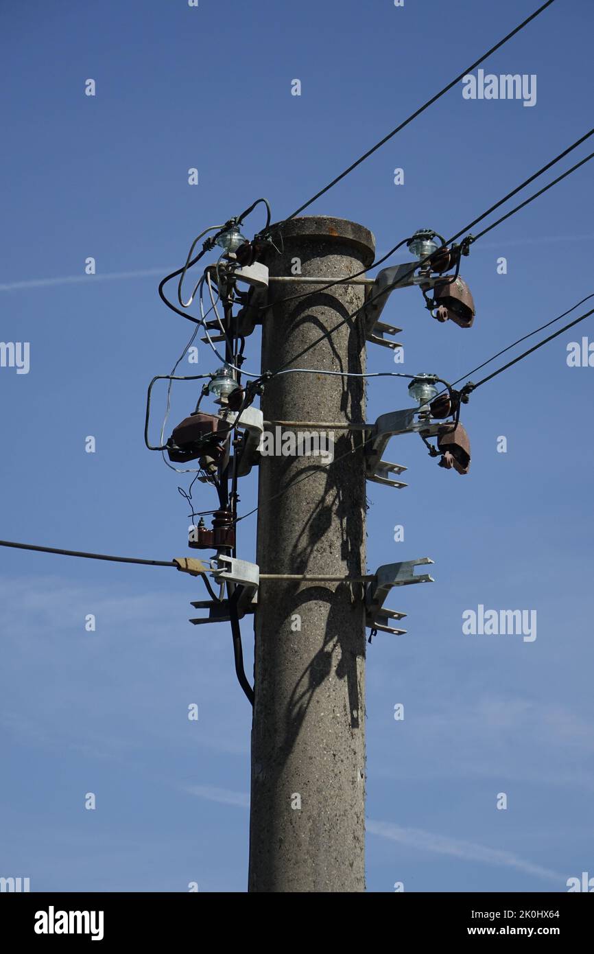 An electric post with wire and a blue sky background Stock Photo - Alamy