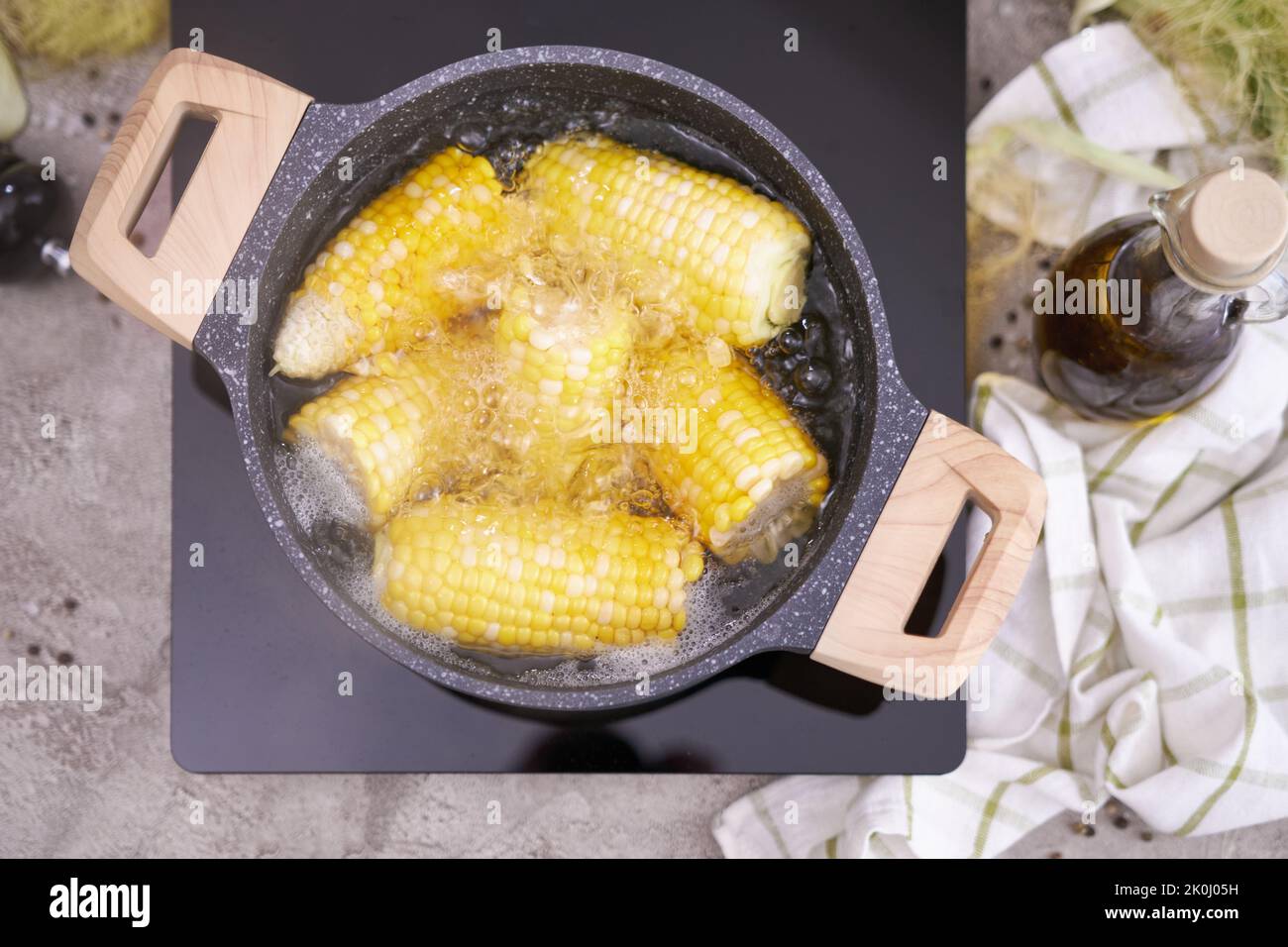 Cooking corn cob in a pot of boiling water with bubbles Stock Photo - Alamy