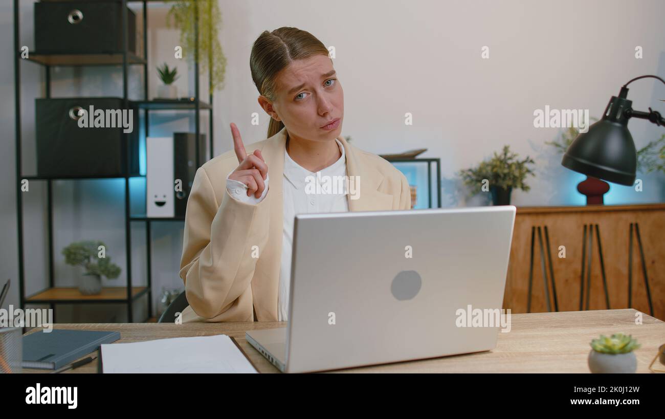 Businesswoman working on laptop computer shakes finger and saying no ...