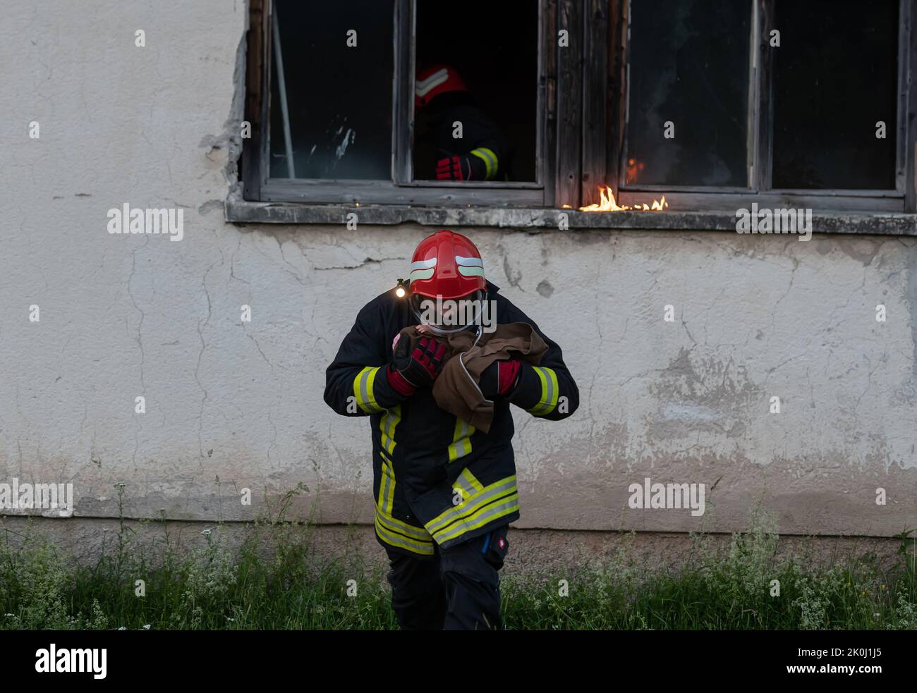 Firefighter hero carrying baby girl out from burning building area from ...