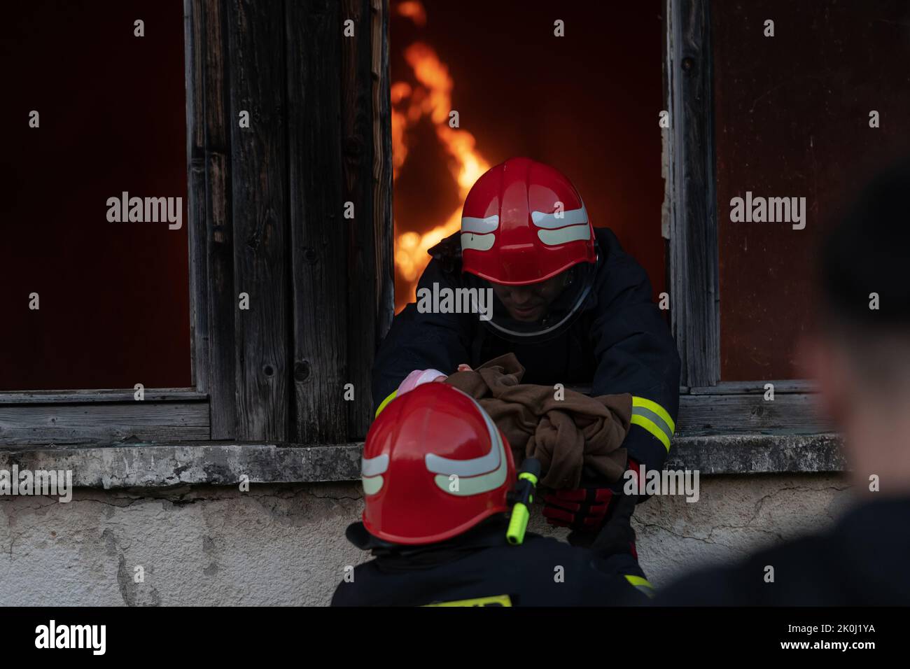 Firefighter hero carrying baby girl out from burning building area from ...
