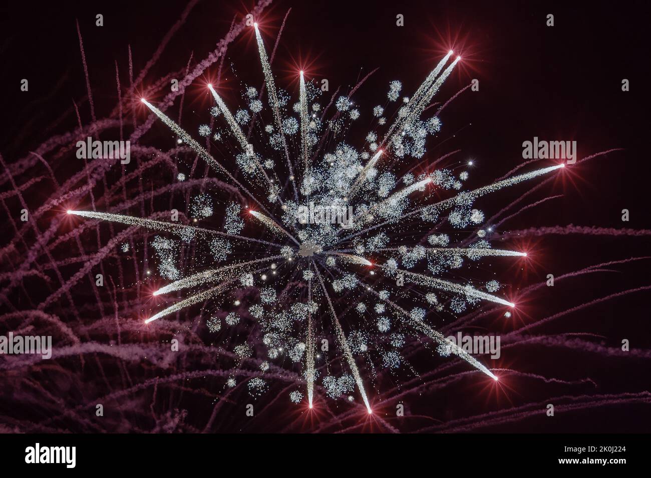 A sparkly burst of a red firework in the night sky Stock Photo - Alamy