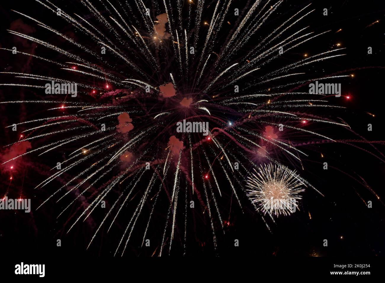 The falling of red firework sparks after bursting in the night sky ...