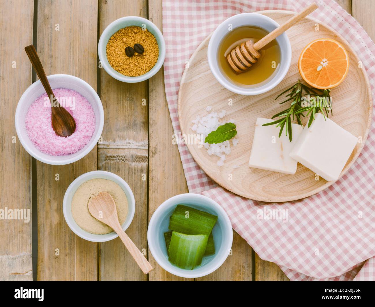 A variety of herbal ingredients like honey and powders on white ...