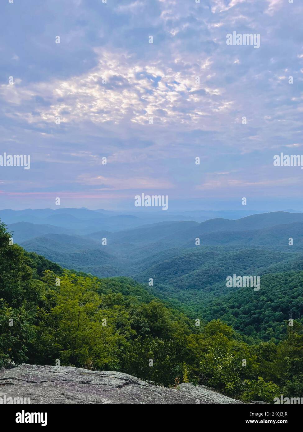 A vertical shot of a bright sunset sky over Preacher Rock in Georgia ...