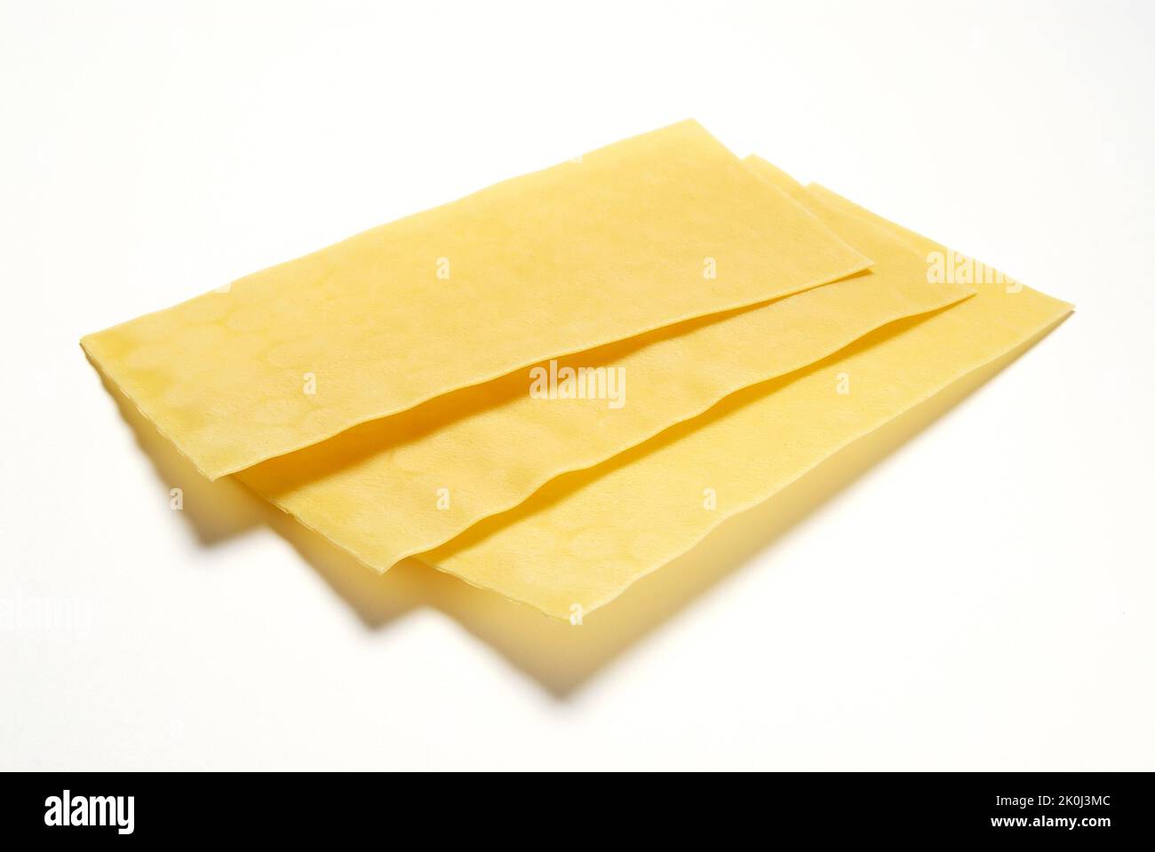 Three layers of raw lasagne pasta cut out on white background Stock ...