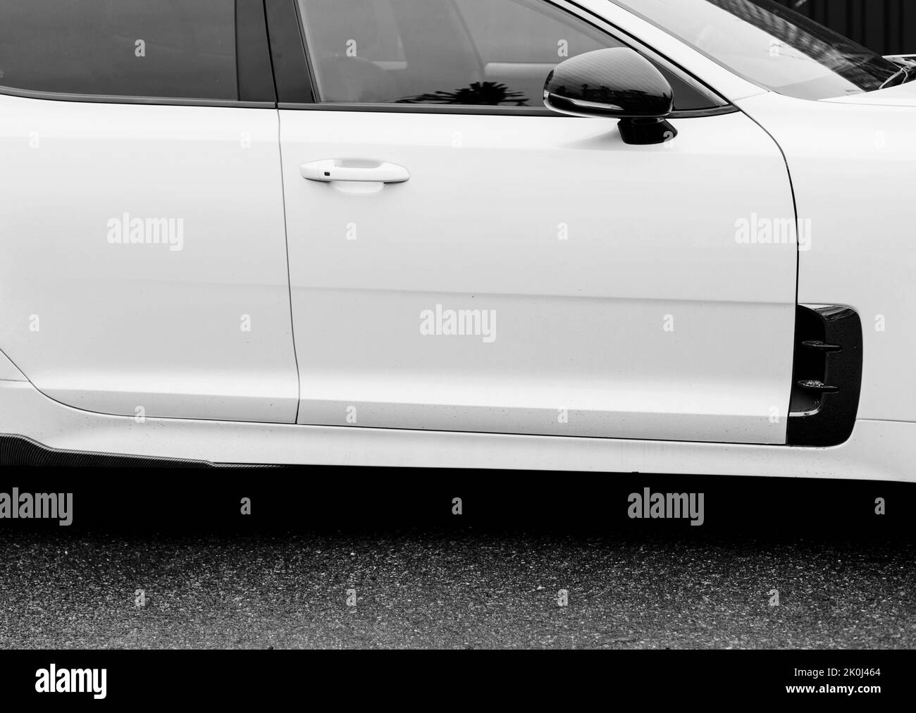 Side rear-view mirror and door on a white modern car. Close-up car ...