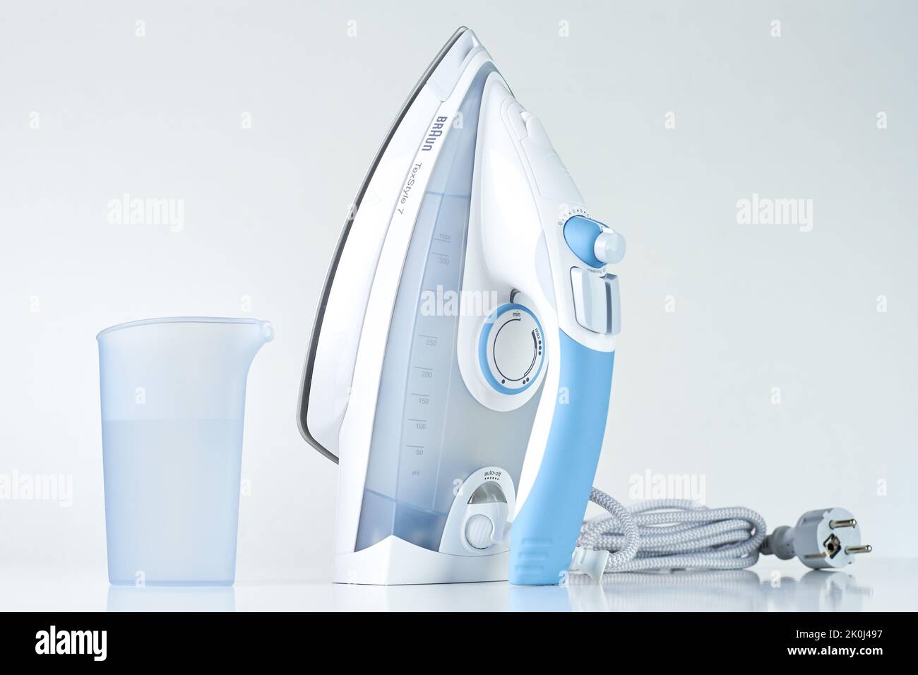 New iron with electrical cable and water for steam on white background ...