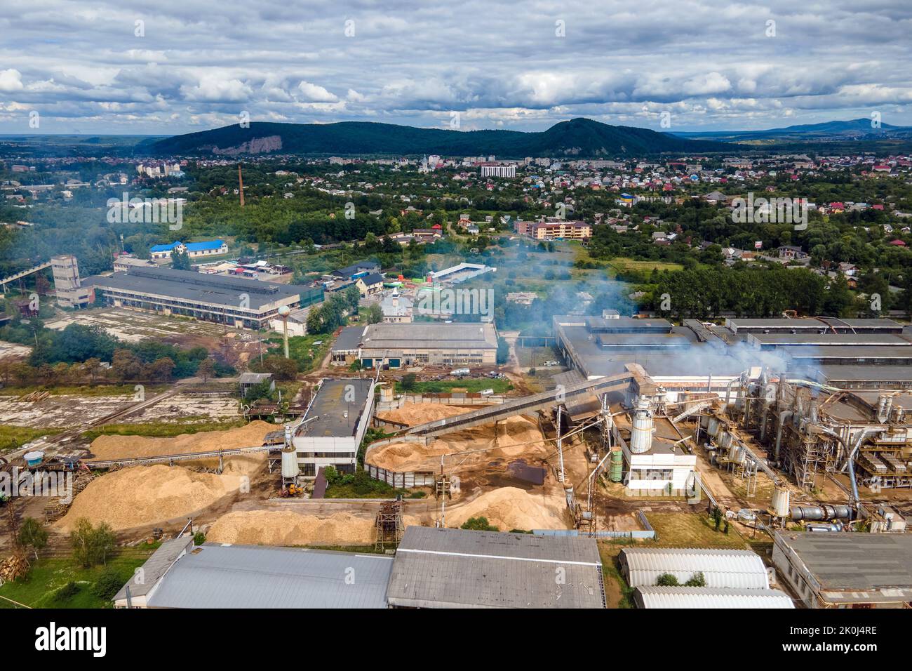 Aerial view of wood processing factory with smoke from production ...
