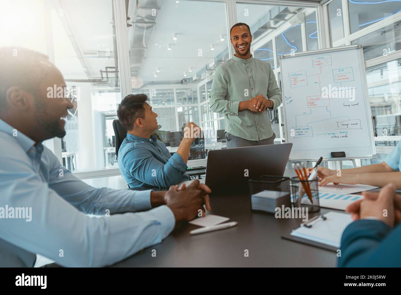 Male business coach or speaker make flip chart presentation to diverse ...