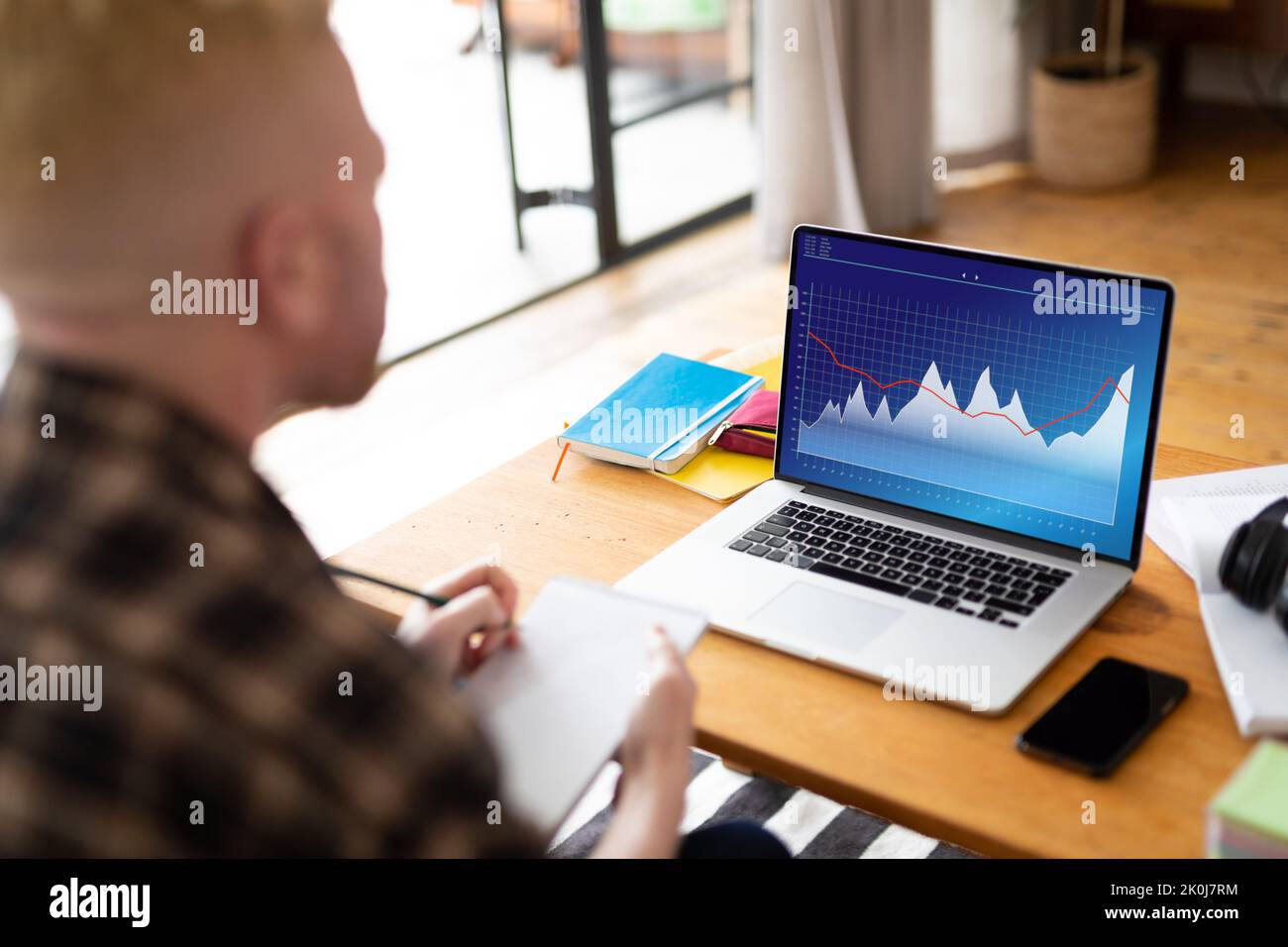 Over shoulder view of caucasian businessman writing notes and using ...