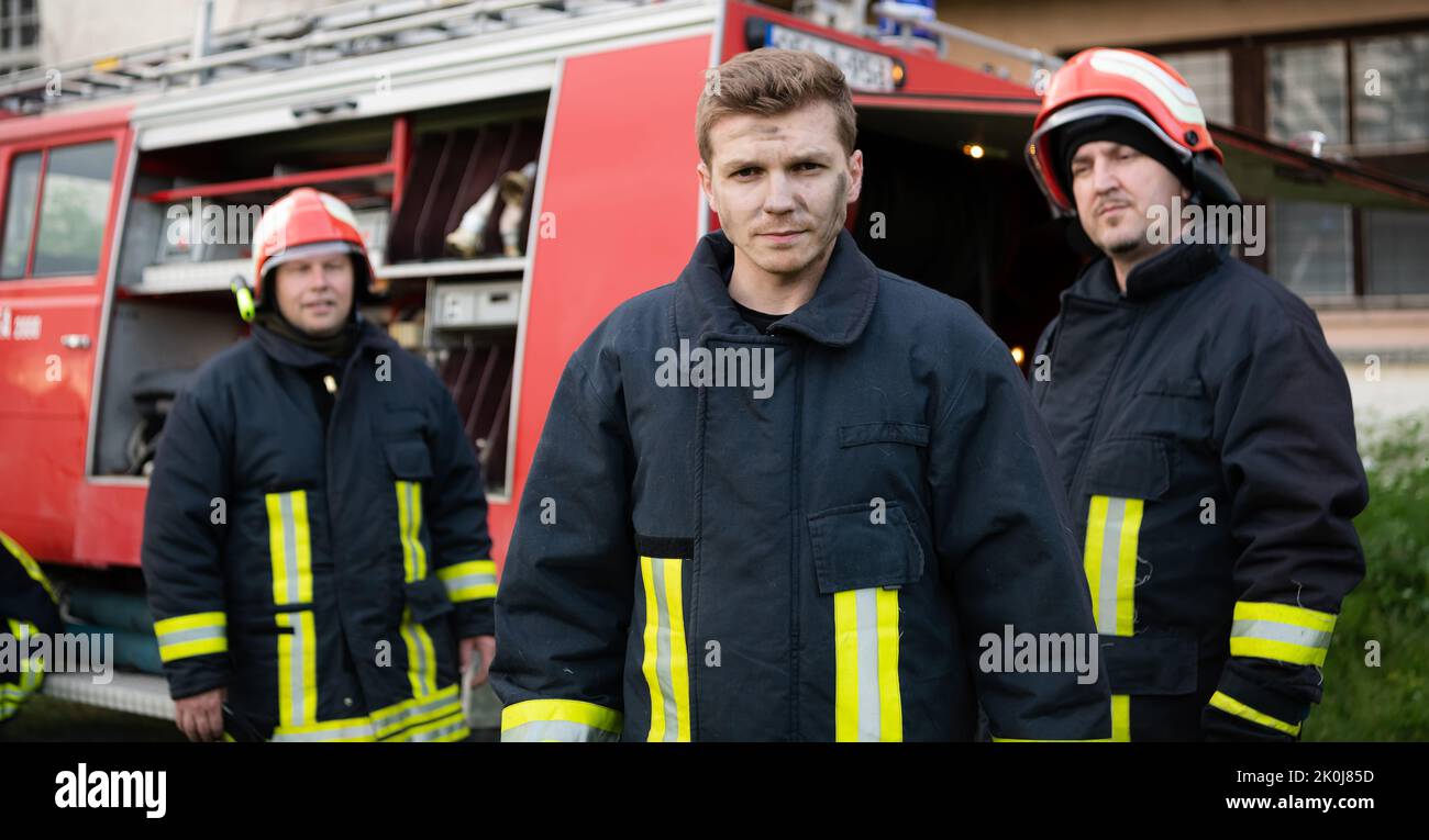 Group of fire fighters standing confident after a well done rescue ...