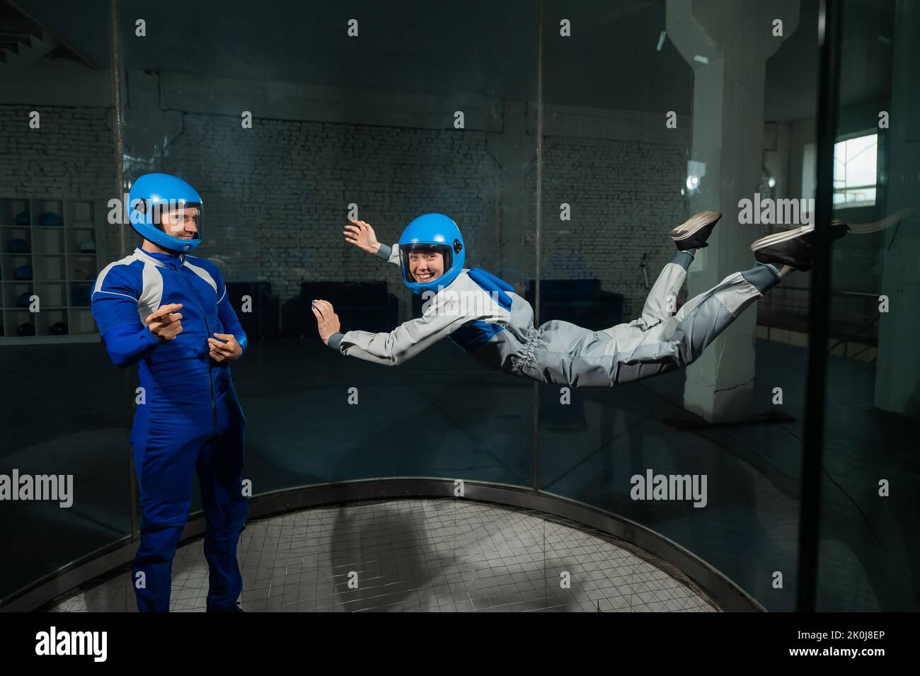 A man teaches a woman how to fly in a wind tunnel. Free fall simulator ...