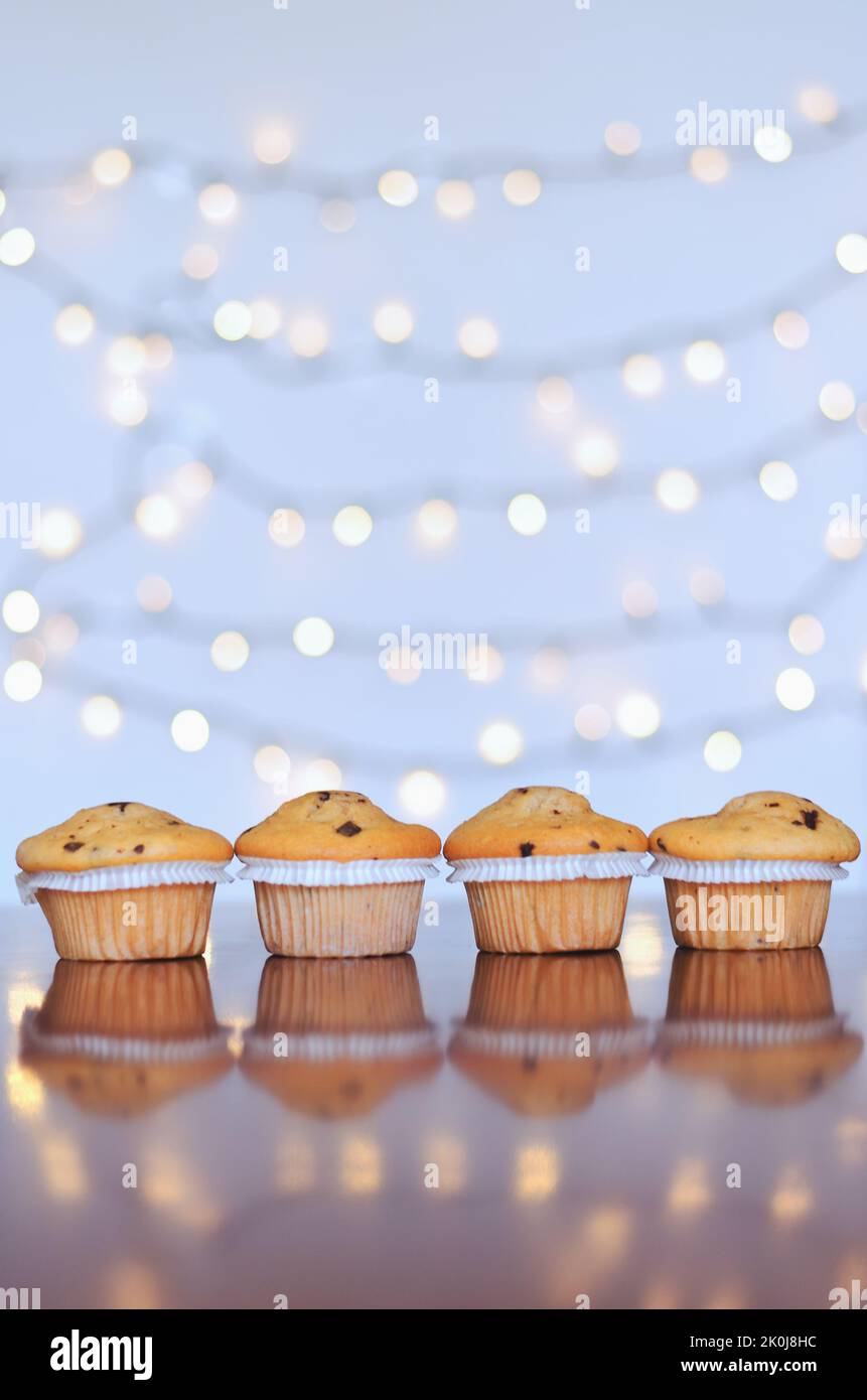 Christmas sweet cupcakes and candles in form of numbers 2023. White background with bokeh. New ...
