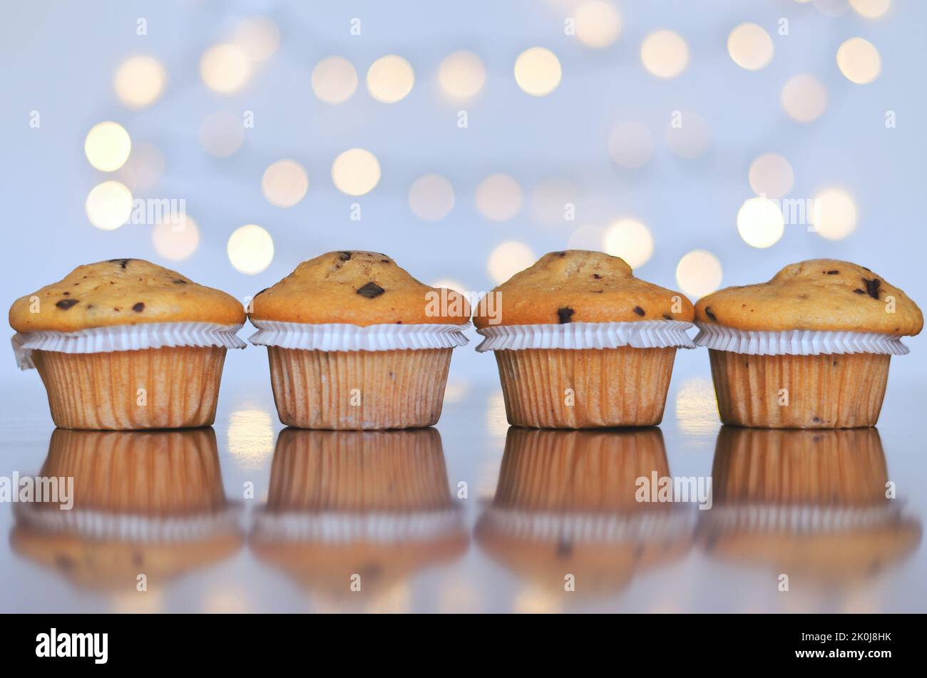 Christmas sweet cupcakes and candles in form of numbers 2023. White background with bokeh. New ...