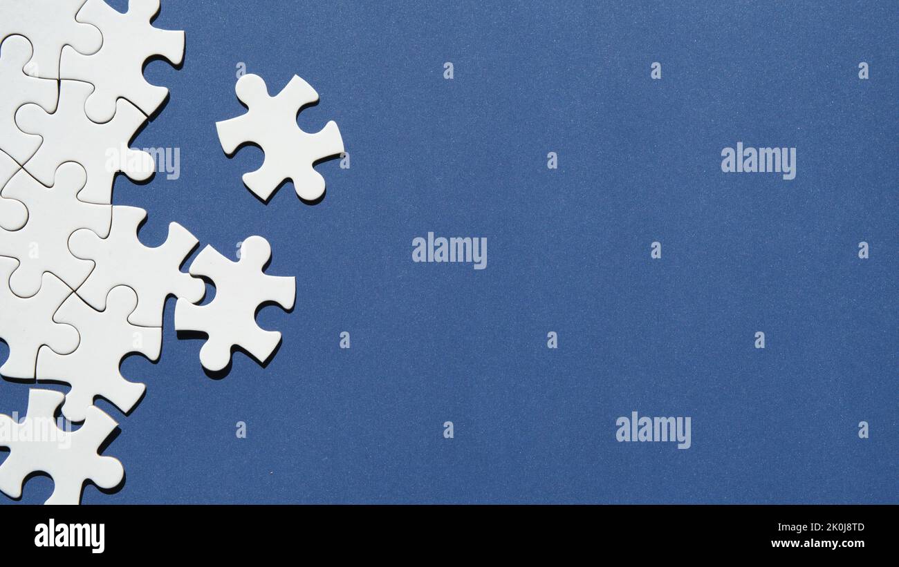 Jigsaw puzzle pieces half assembled and separate. Top view, flat lay on ...