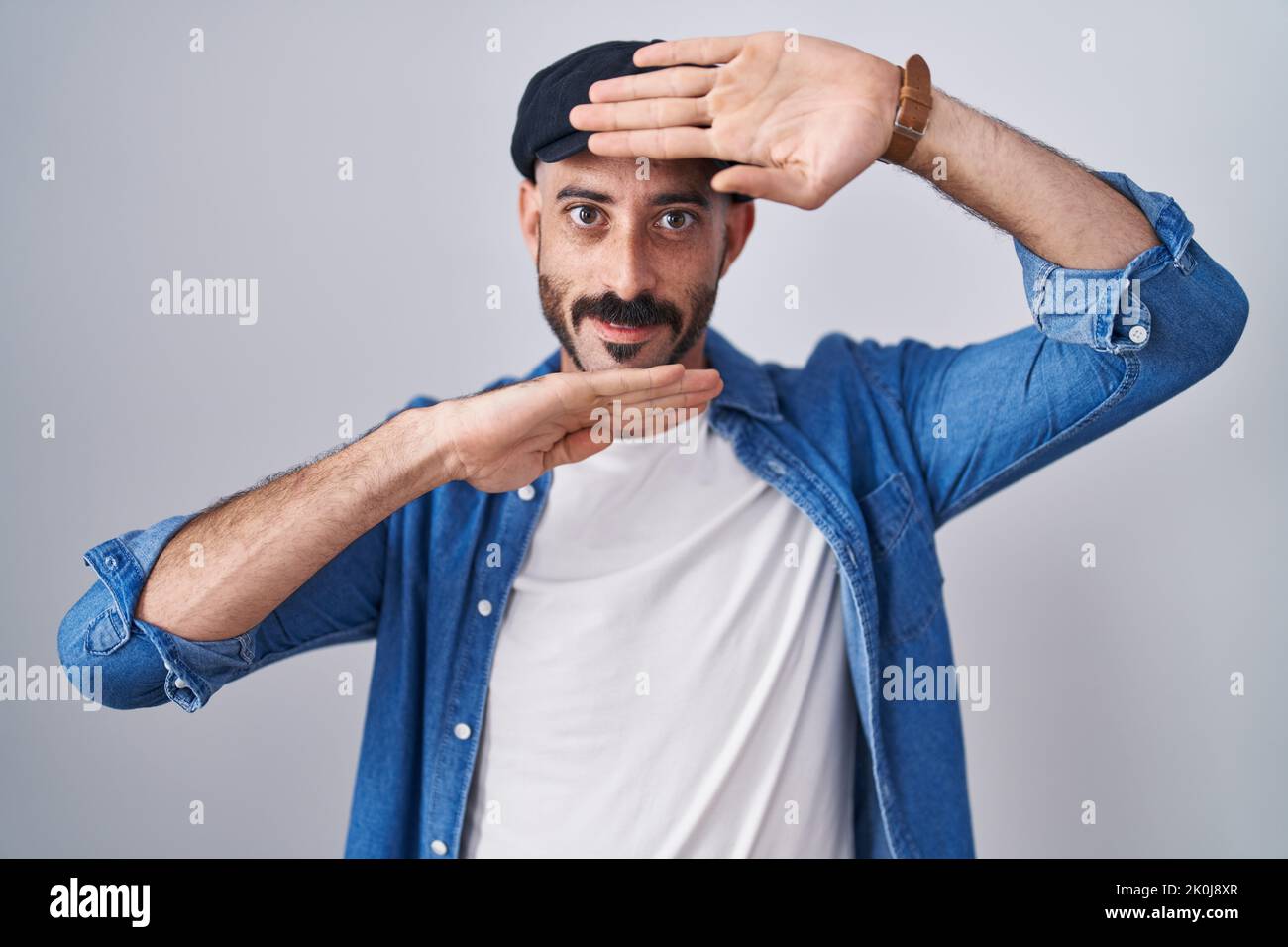 Hispanic man with beard standing over isolated background smiling ...