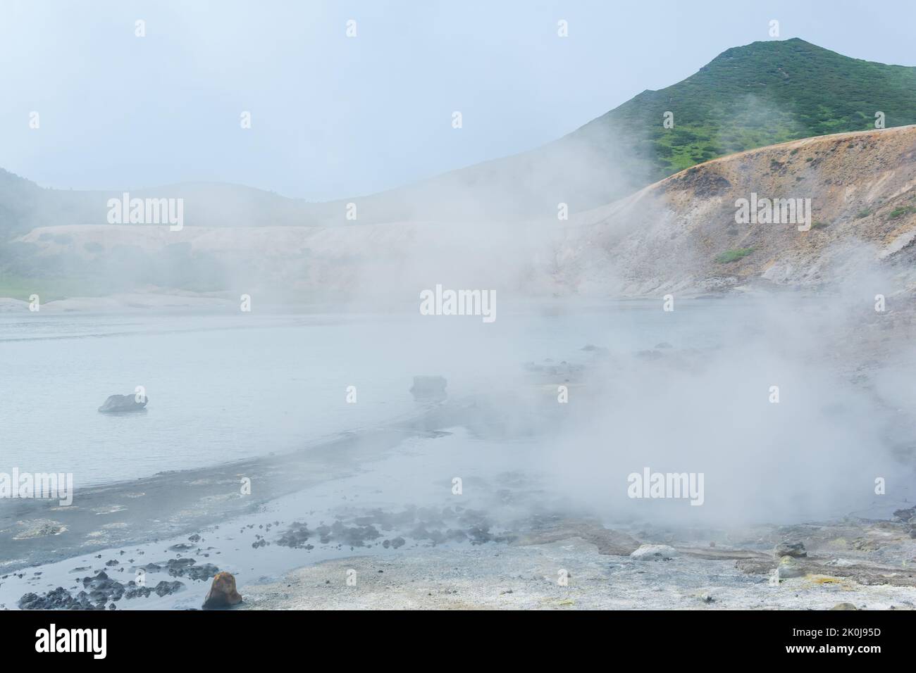 steaming hydrothermal outlet on the shore of the hot lake in the ...