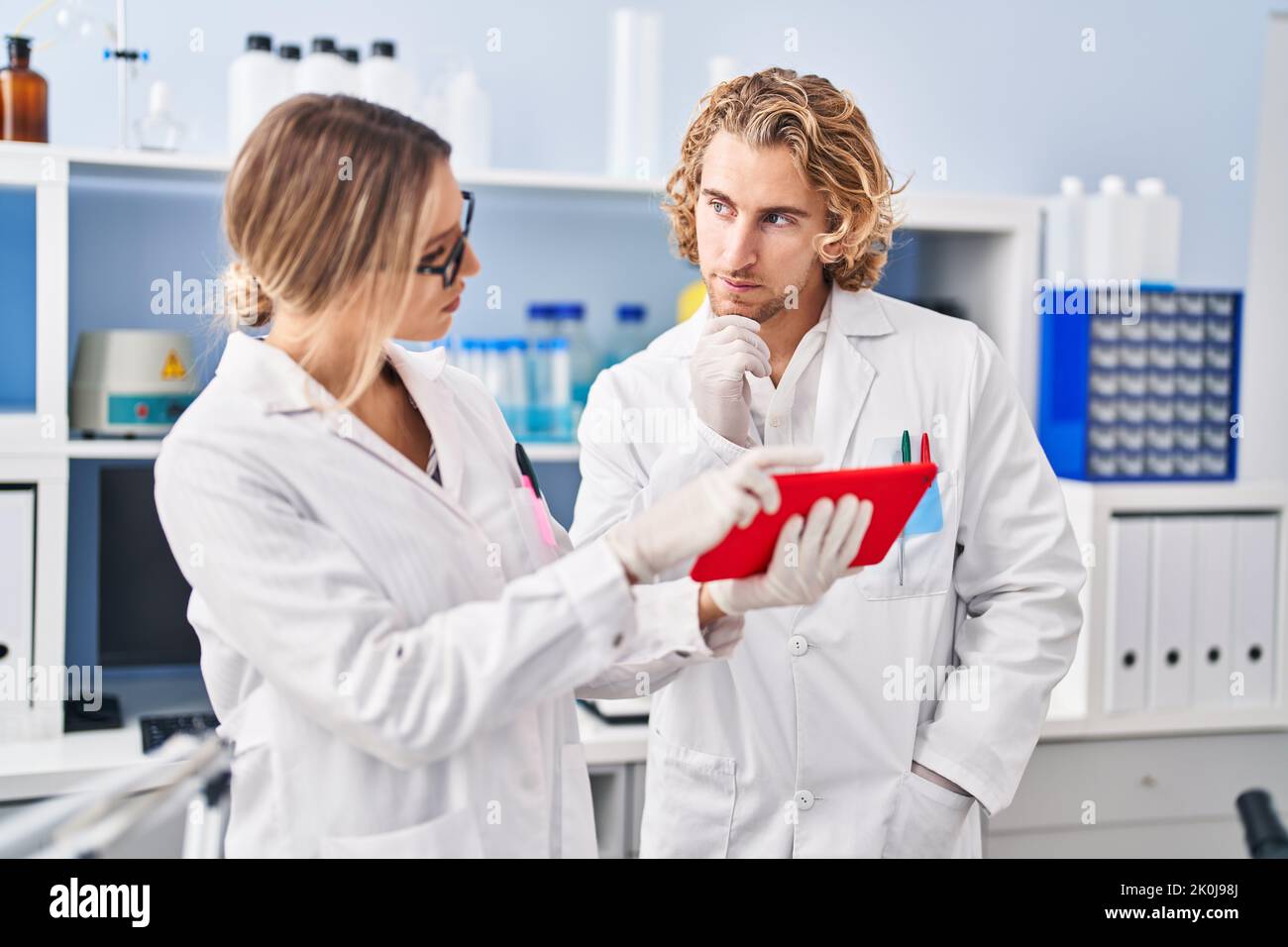 Man and woman wearing scientist uniform using touchpad at laboratory Stock Photo - Alamy