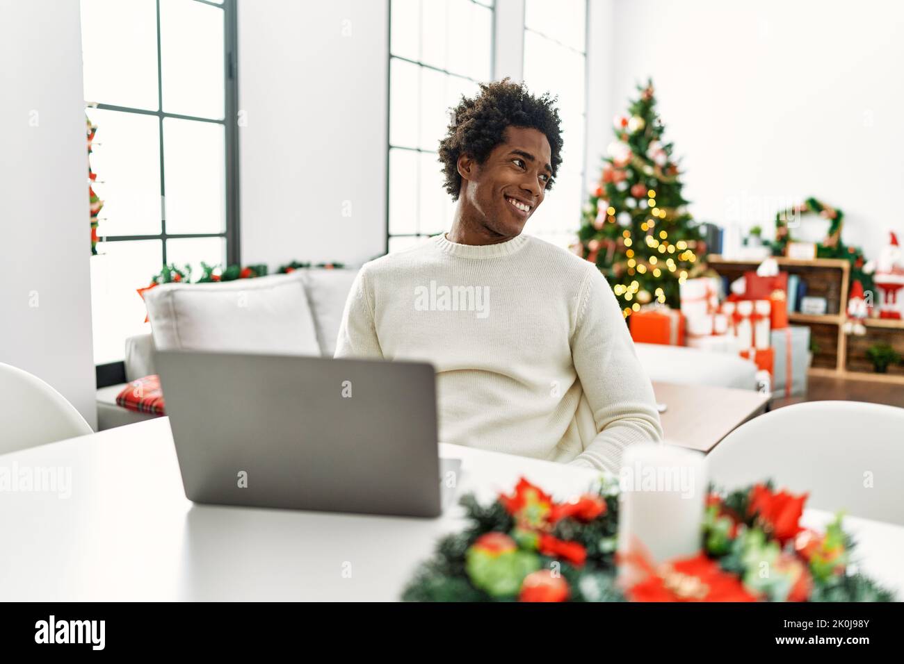 Young african american man using laptop sitting on the table by ...