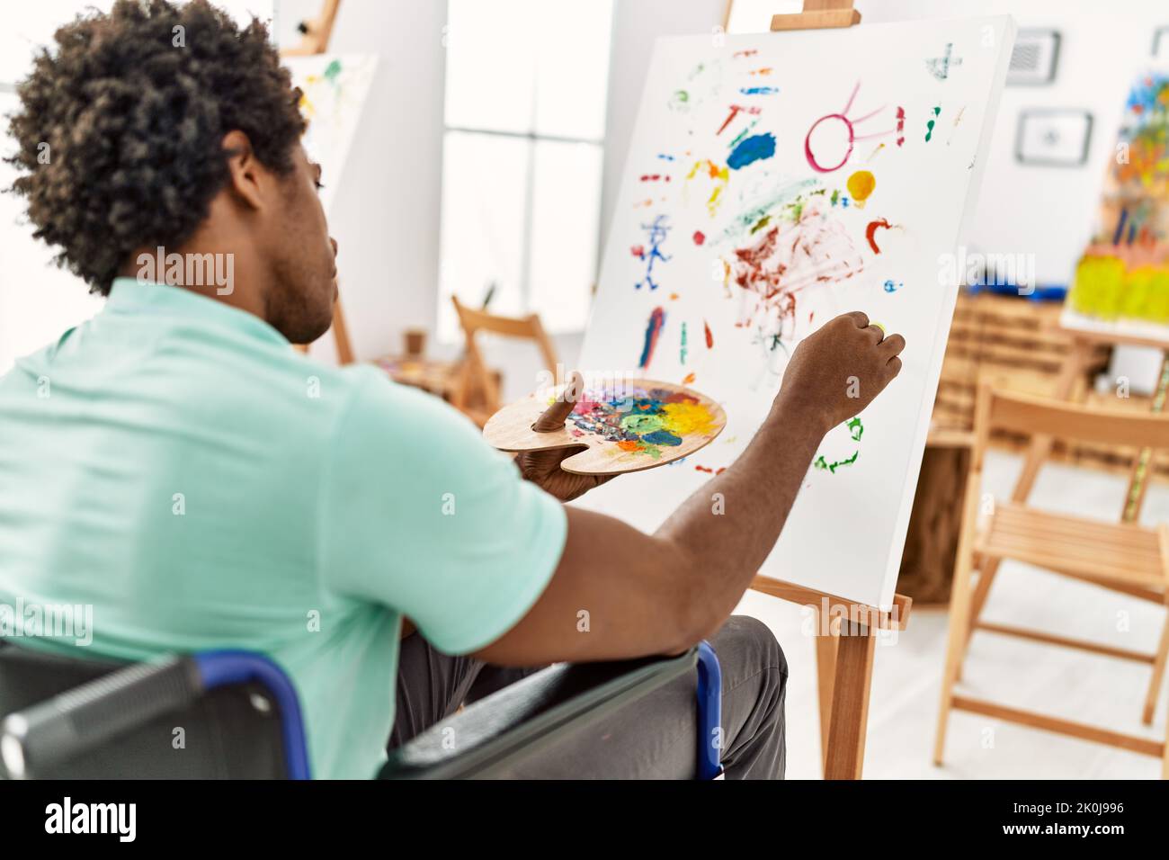 Young african american disabled artist man sitting on wheelchair ...