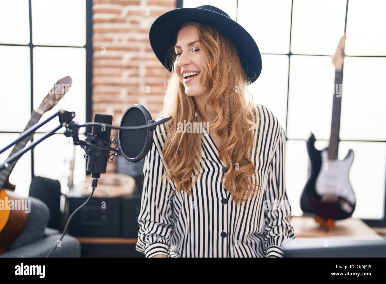 Young blonde woman musician singing song playing piano keyboard at ...