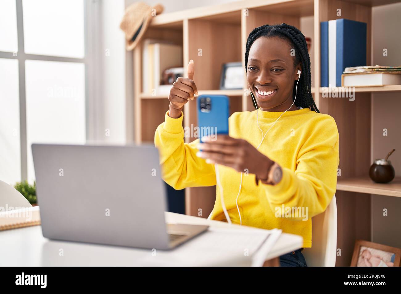 Beautiful black woman doing video call with smartphone smiling happy ...