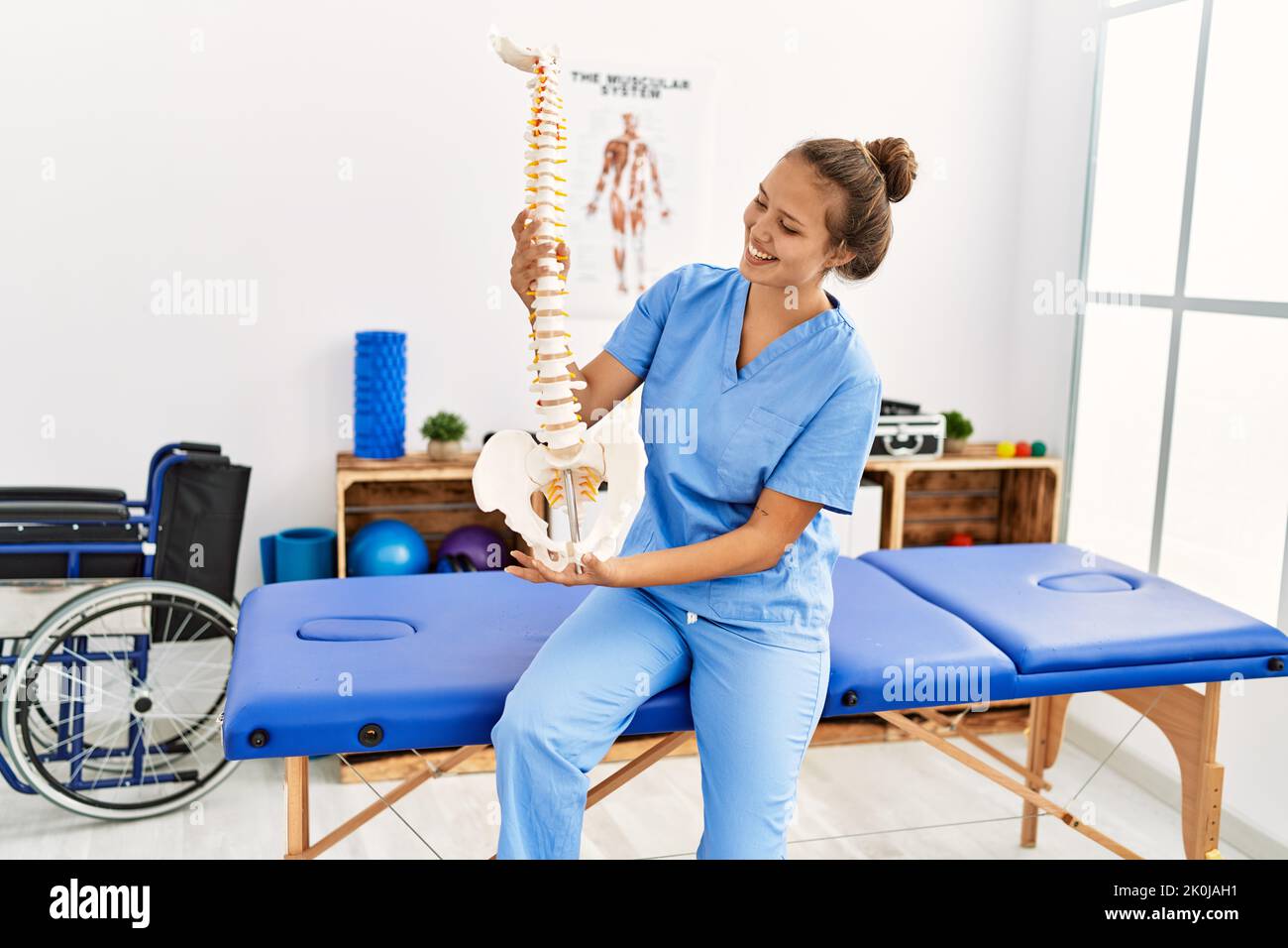 Young beautiful hispanic woman physiotherapist smiling confident ...