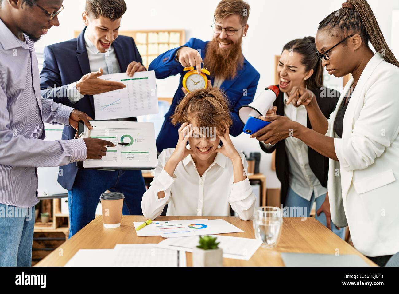 Group of business workers screaming to stressed partner at the office ...