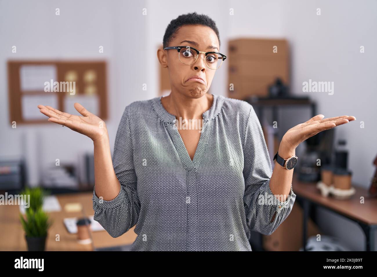 African american woman working at the office wearing glasses clueless ...