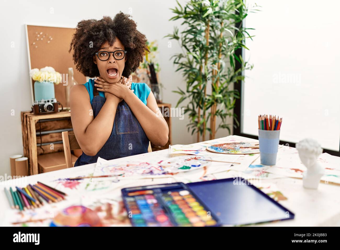 Beautiful african american woman with afro hair painting at art studio ...