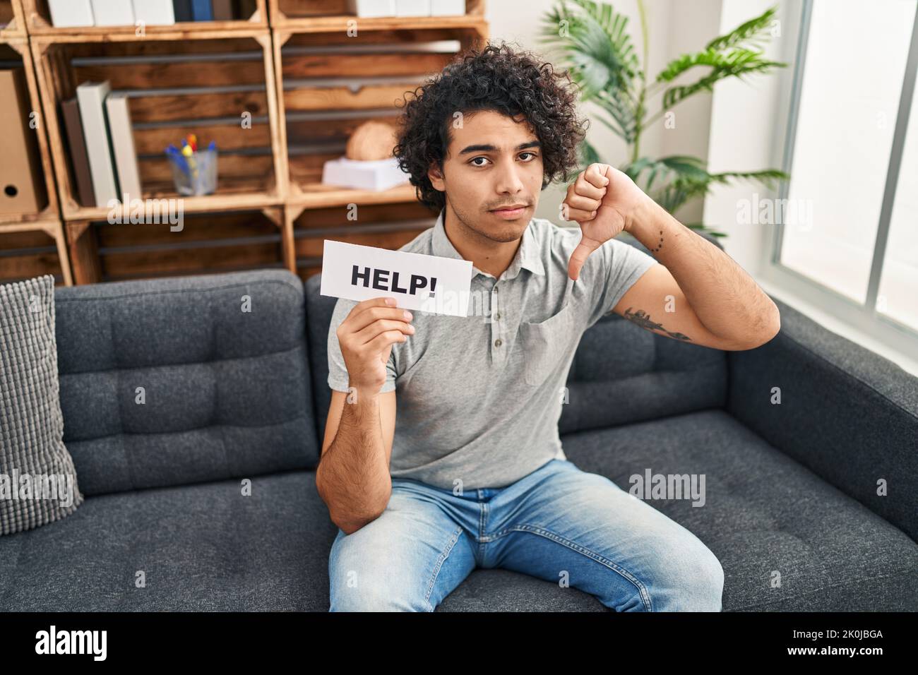 Hispanic man with curly hair asking for help with angry face, negative ...