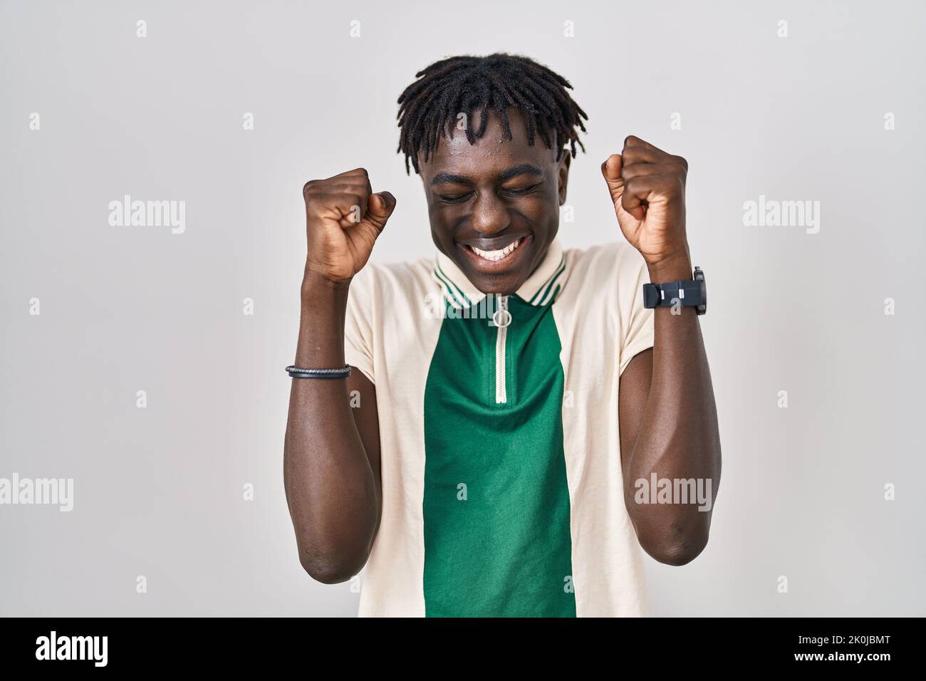 African man with dreadlocks standing over isolated background excited ...