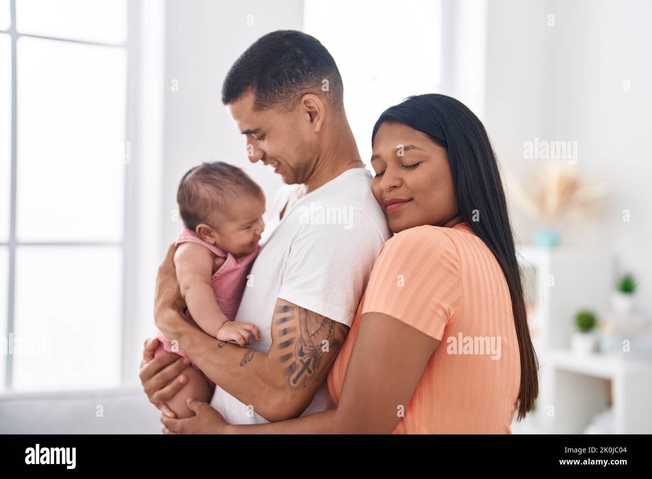 Hispanic family hugging each other standing at home Stock Photo - Alamy