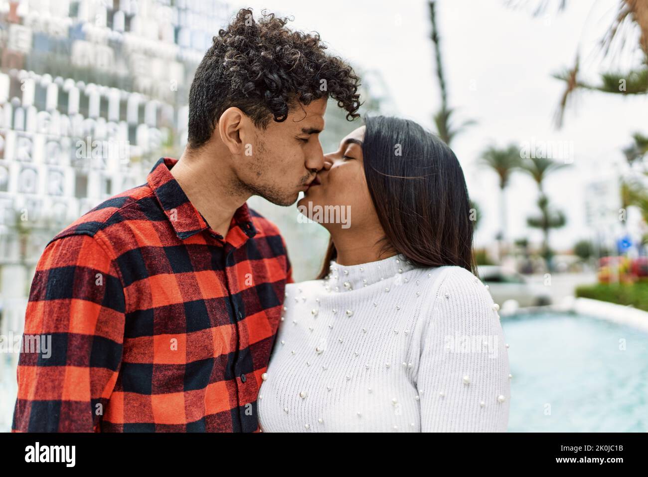Young latin couple kissing and hugging at the city Stock Photo - Alamy