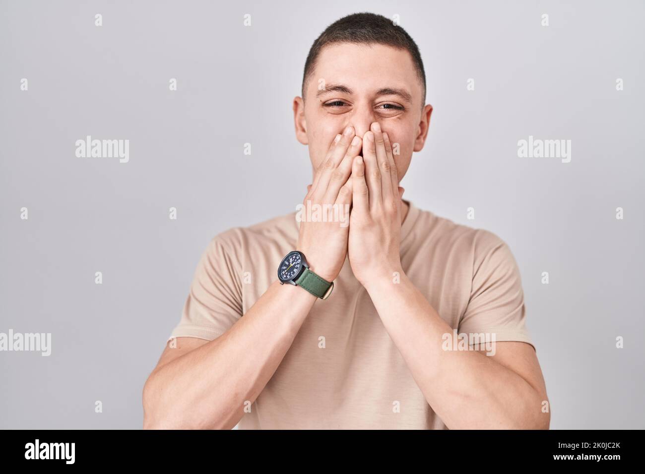 Young man standing over isolated background laughing and embarrassed ...
