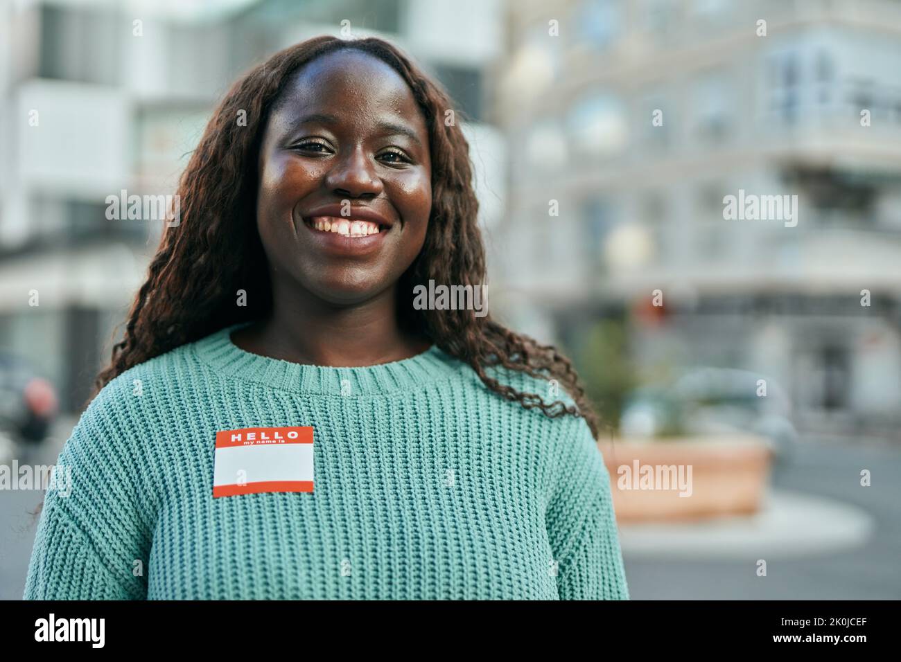 Young african woman smiling happy wearing hello i am sticker at the ...