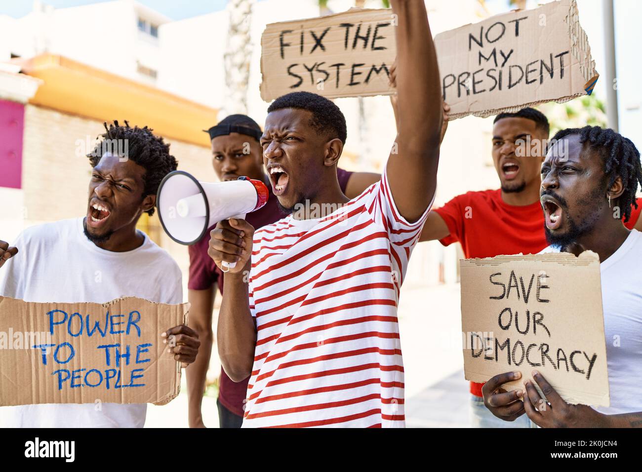 Group of young african american activists protesting holding banner and ...