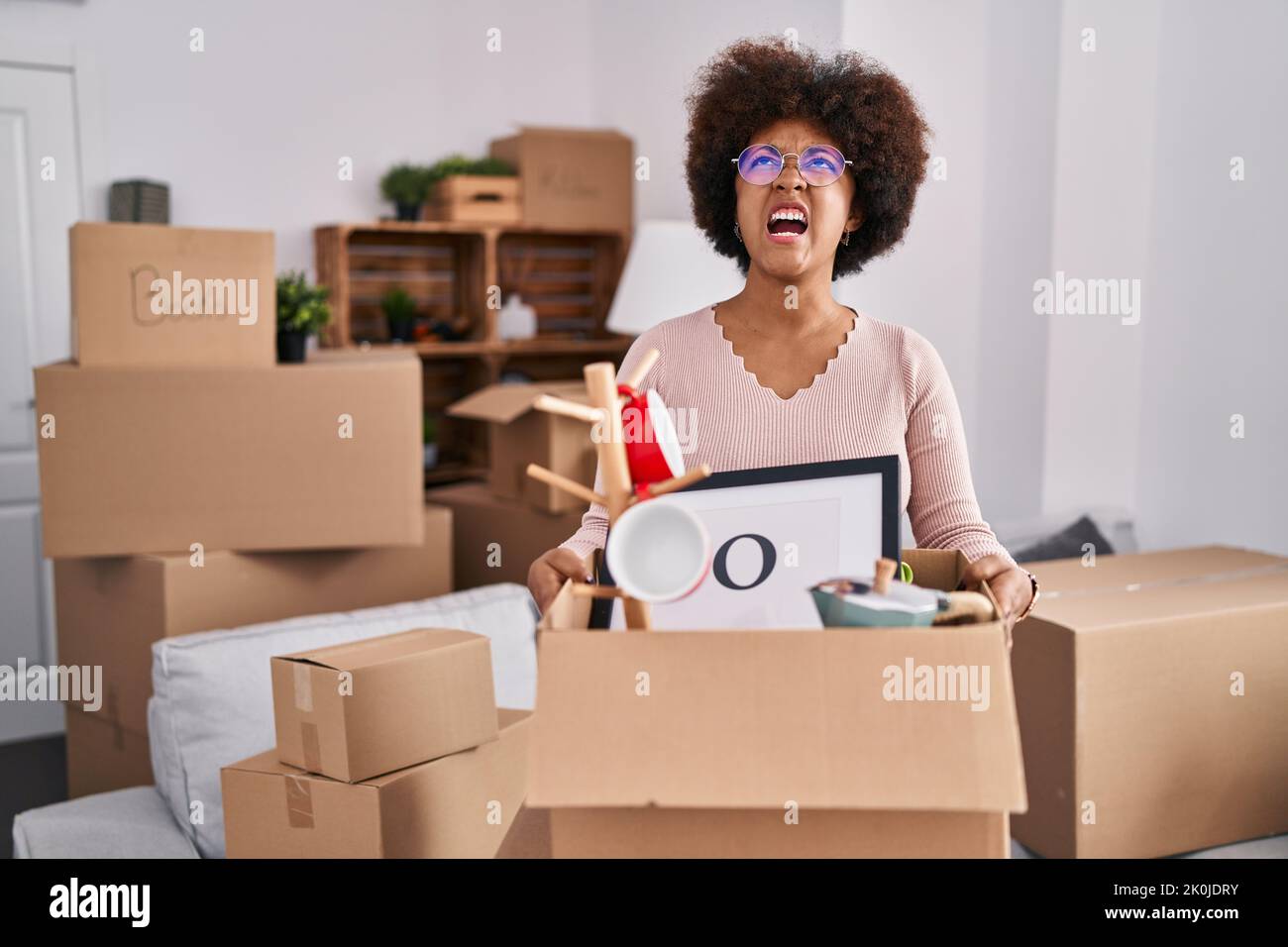 Young african american woman moving to a new home angry and mad ...