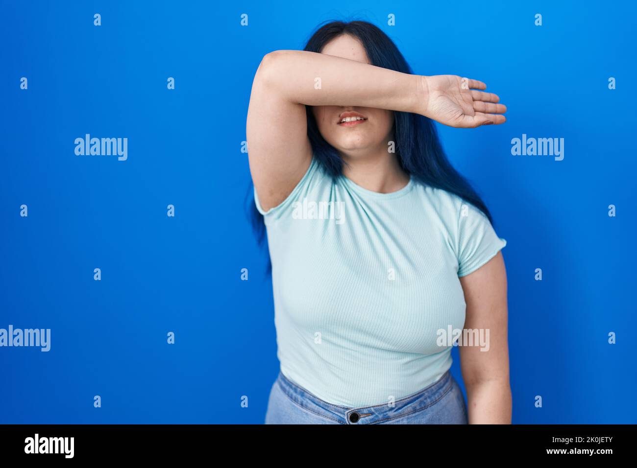 Young Modern Girl With Blue Hair Standing Over Blue Background Covering 3972