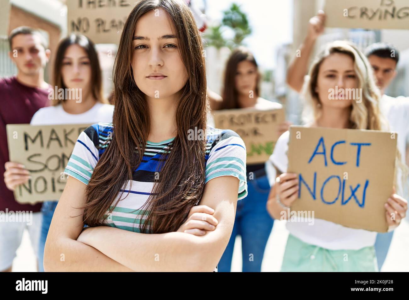 Young activist woman with arms crossed gesture standing with a group of ...