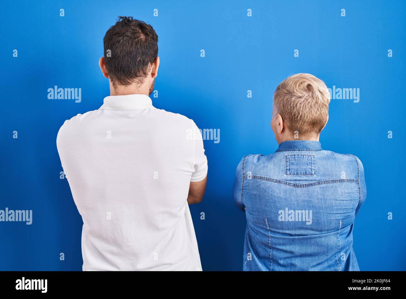 Young brazilian mother and son standing over blue background standing ...