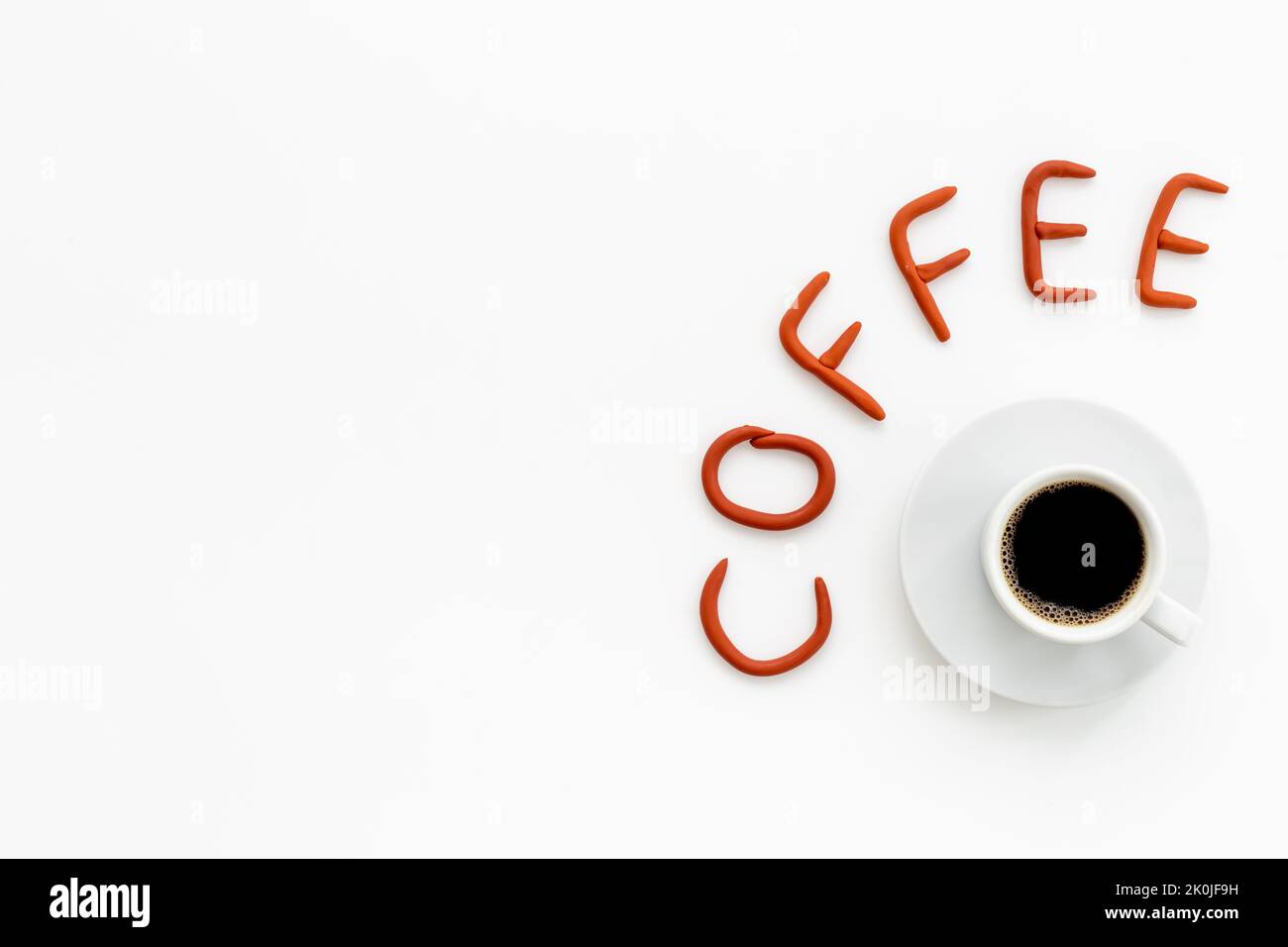 White cup of hot black coffee with rubber letters. Coffee break concept ...