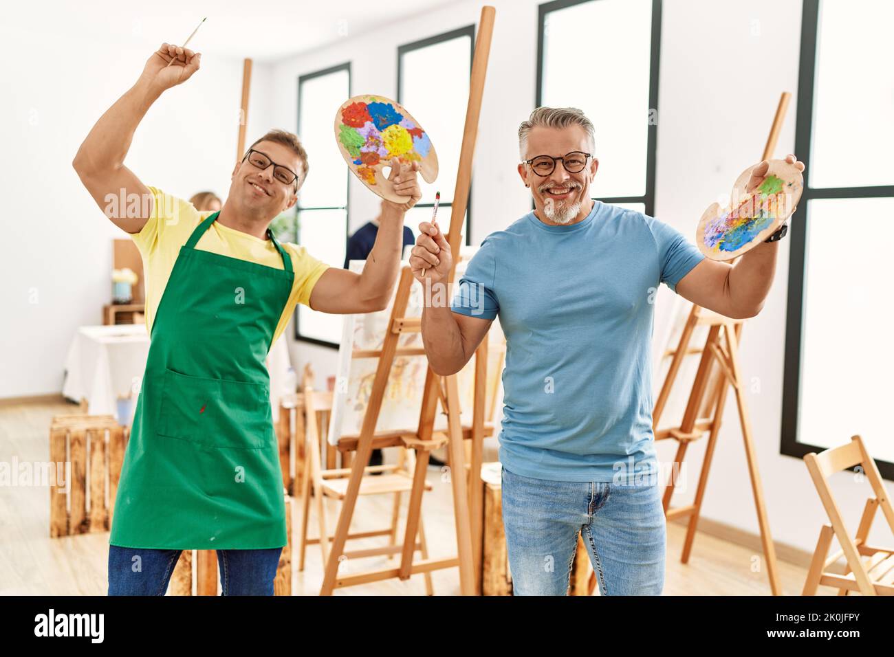Group of middle age people drawing at art studio. Two students smiling ...